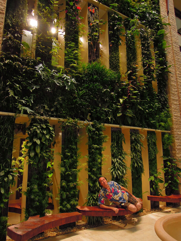 Patrick Blanc lying on a wooden bench in front of the Beach Suites ...